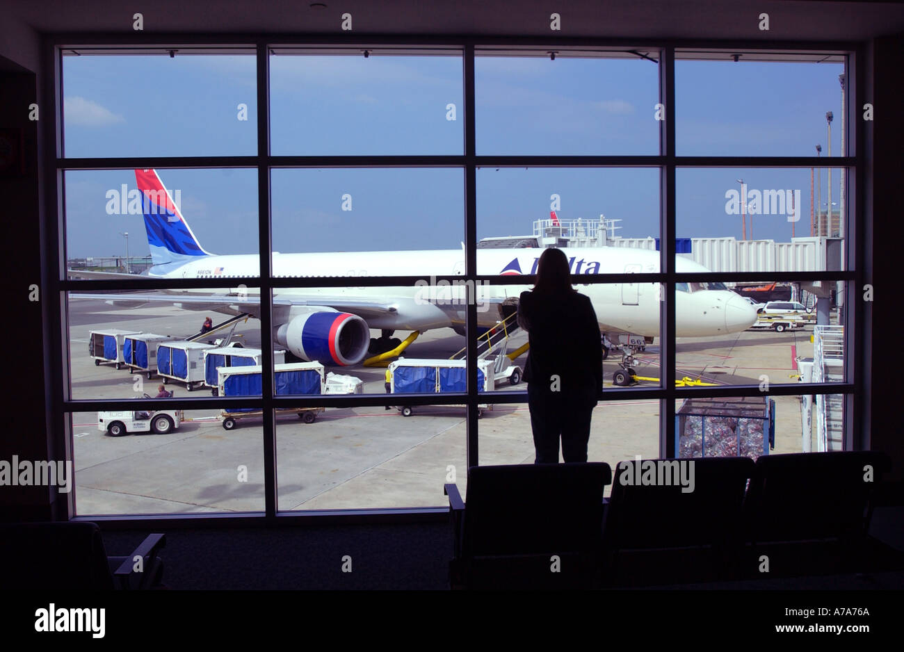 silhouetted figure looking out an airport window Stock Photo - Alamy