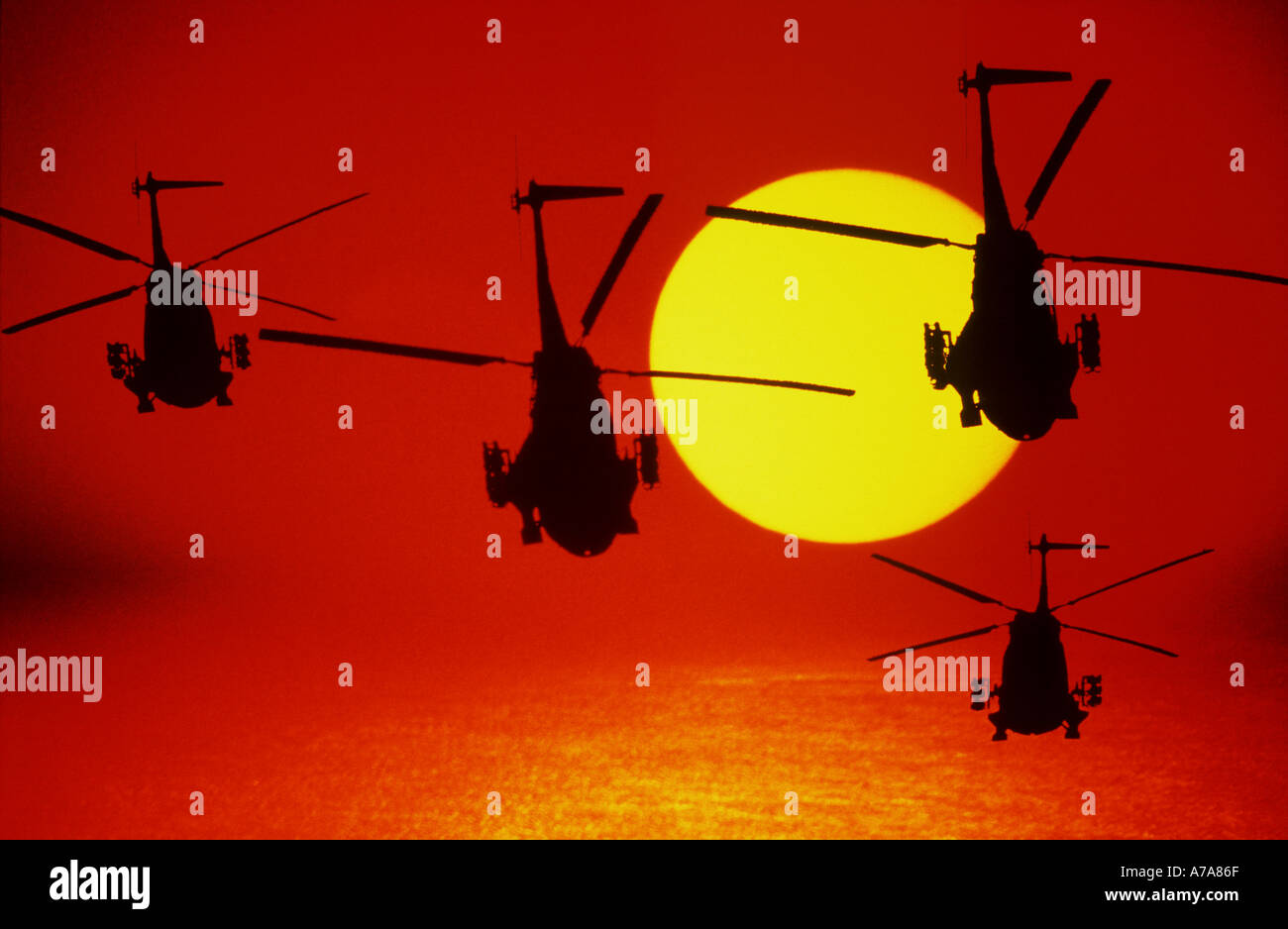Four Heavily Armed Helicopters flying into huge boiling Sunset over Sea ...
