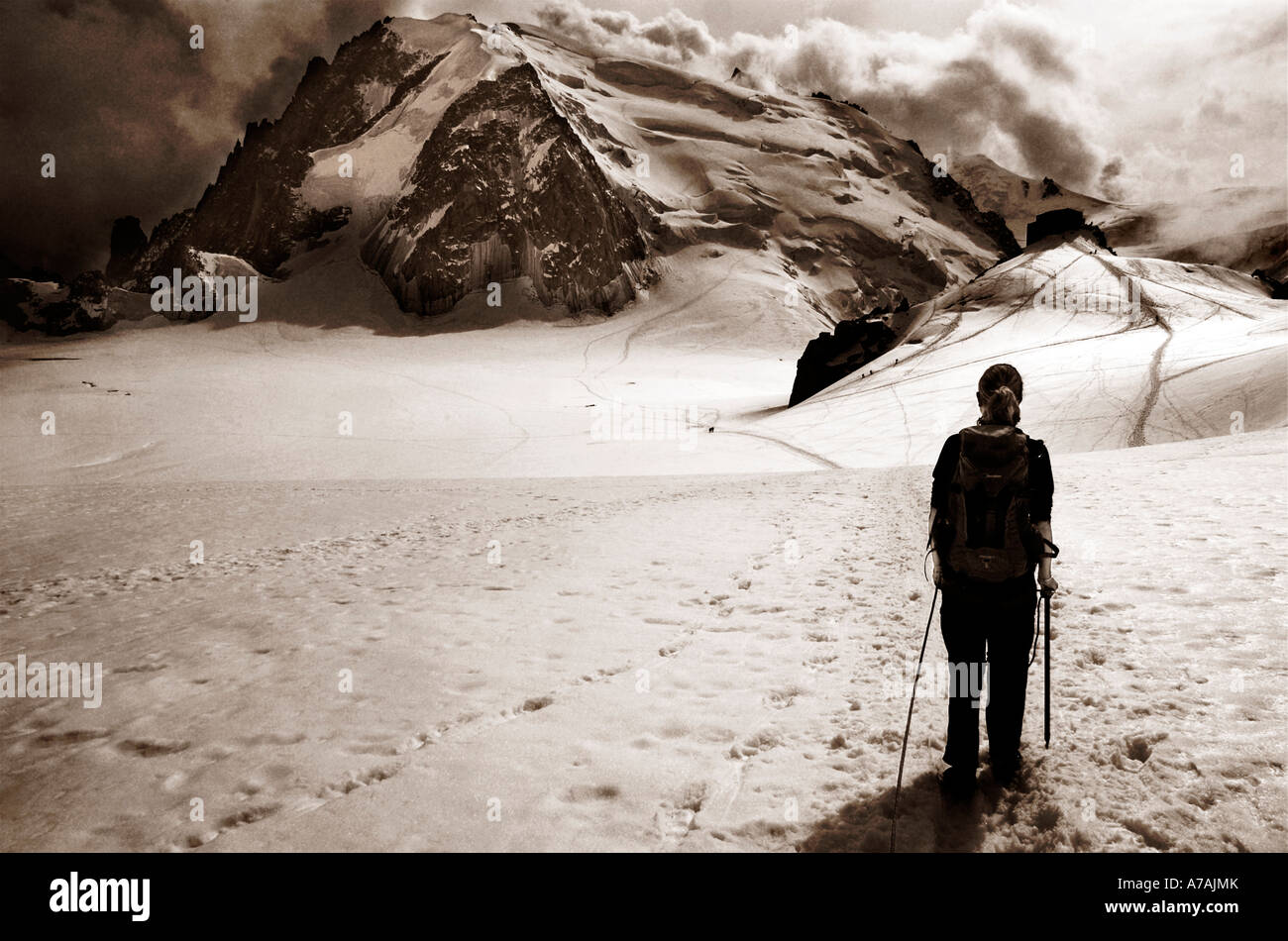 A roped lady climber on a glacier with Mont Blanc de Tacul behind ...