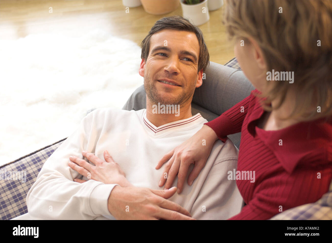woman looking down on man lying on sofa Stock Photo - Alamy