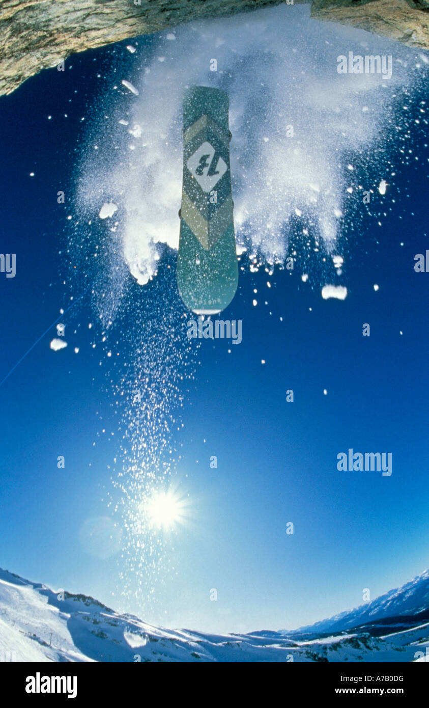 Shot of the underside of a snowboard as the snowboarder comes off a ...