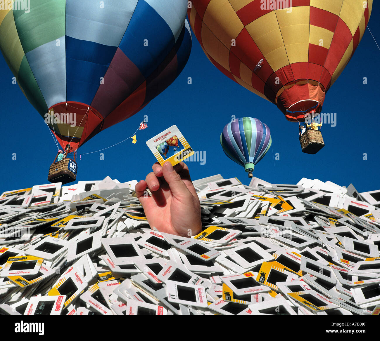 Hand holding slide sticking up from pile of transparencies against a ...