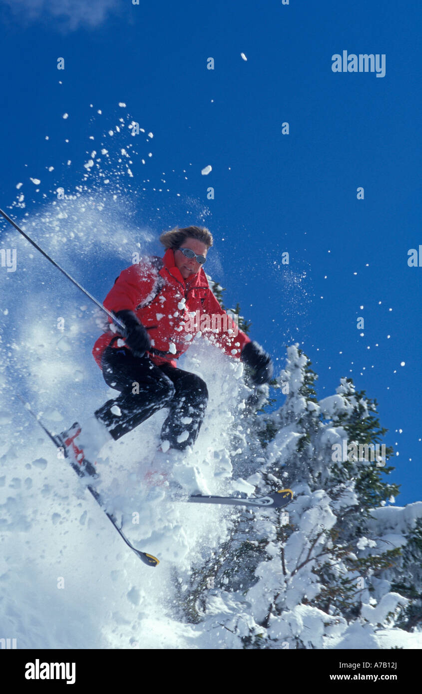 Female skier coming off a steep slope in deep powder off piste Stock ...
