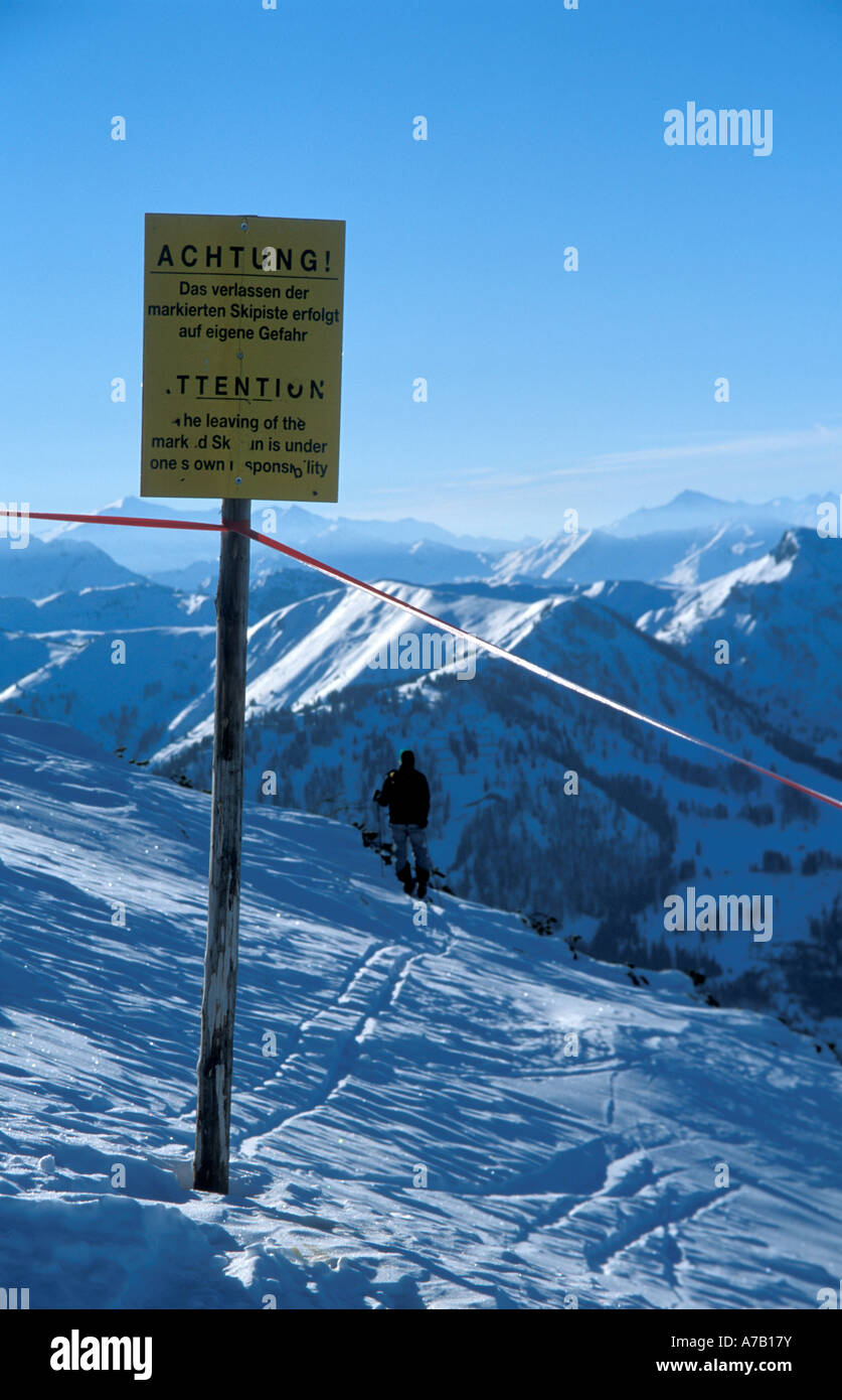 Skier going off piste flaunting a warning sign on the slopes at Flachau ...
