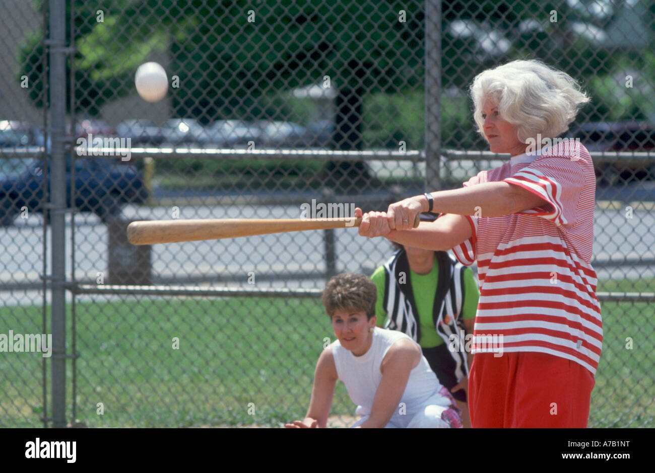 Woman hitting softball Stock Photo - Alamy
