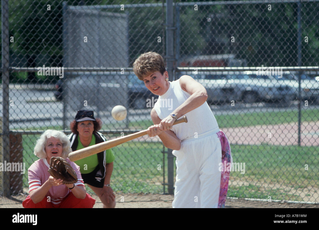 Mature woman hits softball Stock Photo - Alamy
