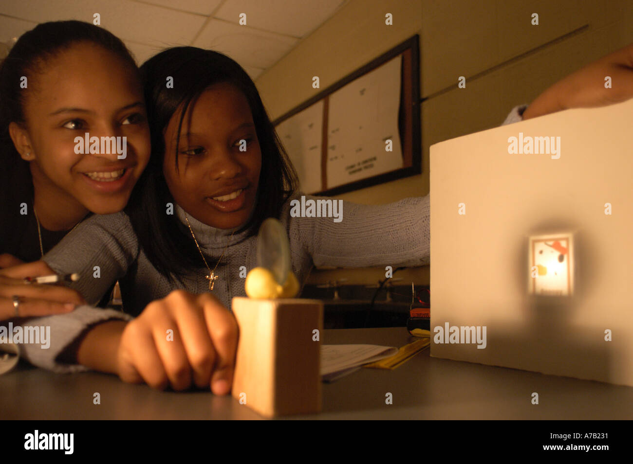 Two African American students doing an optics experiment in a physics ...