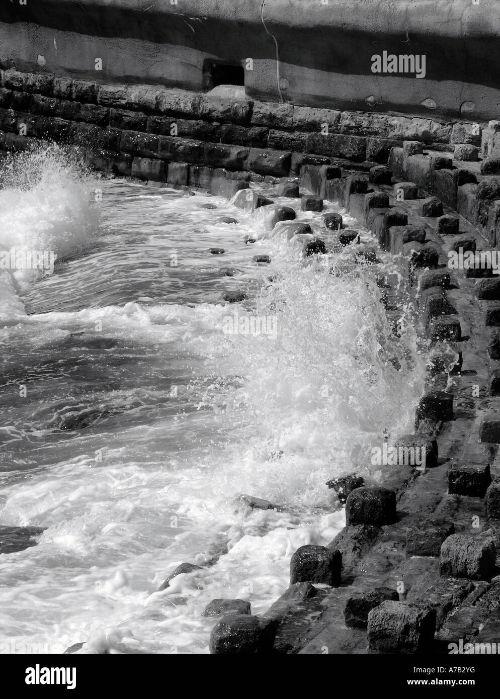 Waves hitting sea defense walls Stock Photo - Alamy