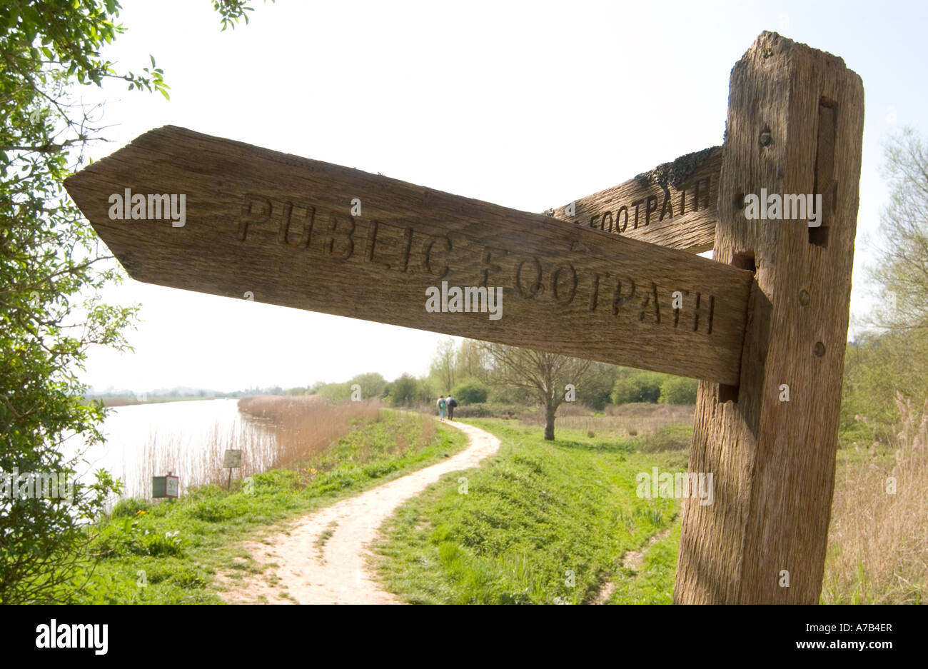 Hikers walking along the footpath beside the tidal River Arun near ...