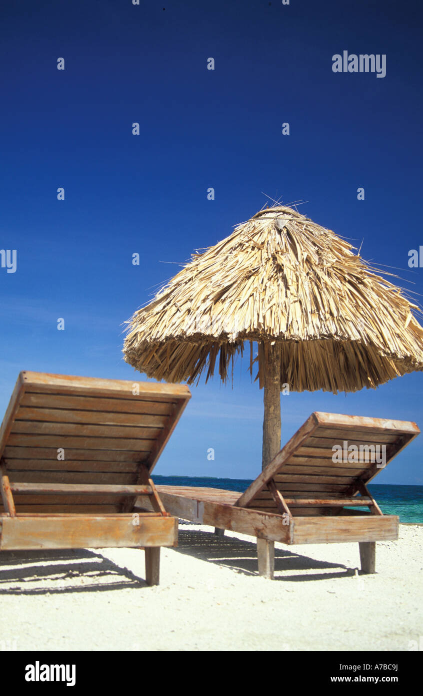 wooden beach chairs and thatch sun shade on sandy beach Stock Photo - Alamy