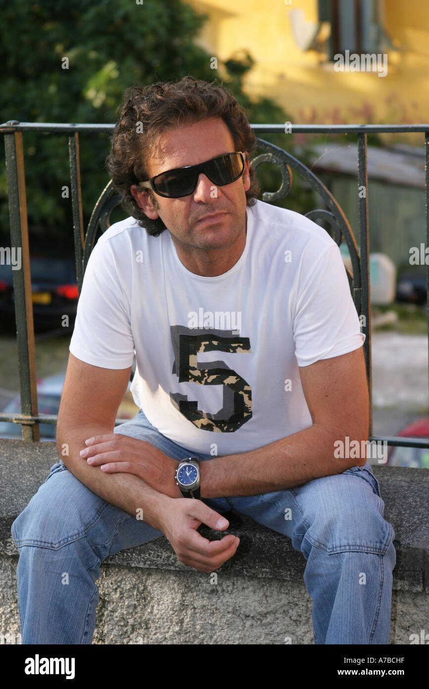 Italian man sitting on the street wall and looking to the camera Stock ...