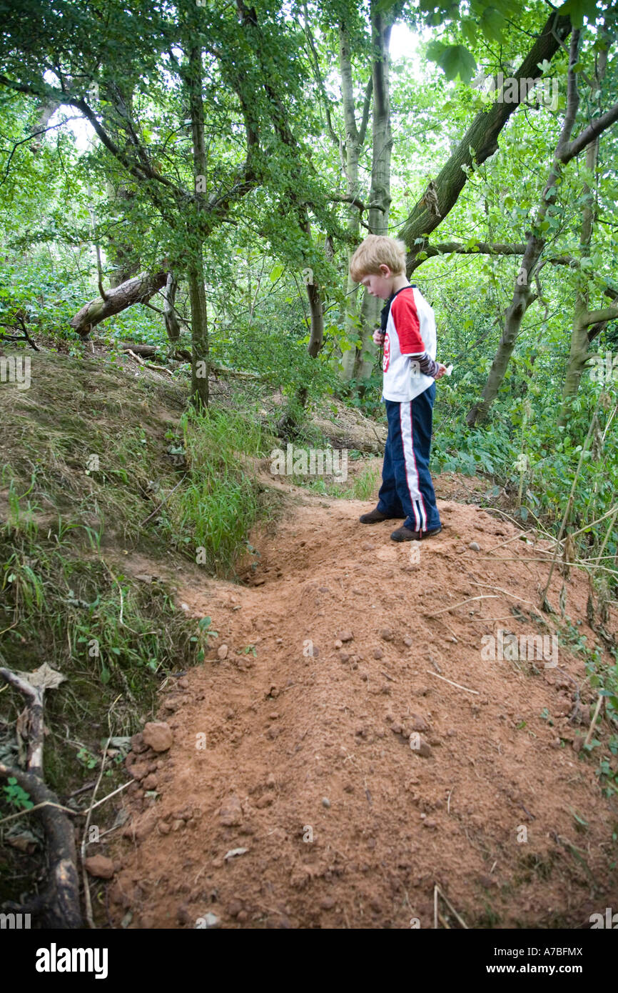 Young boy standing on mound outside a badger sett Stock Photo - Alamy