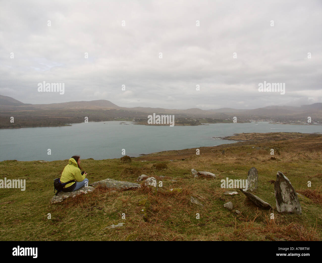 A hiker rests near a stone circle on Bere Island, Ireland Stock Photo ...