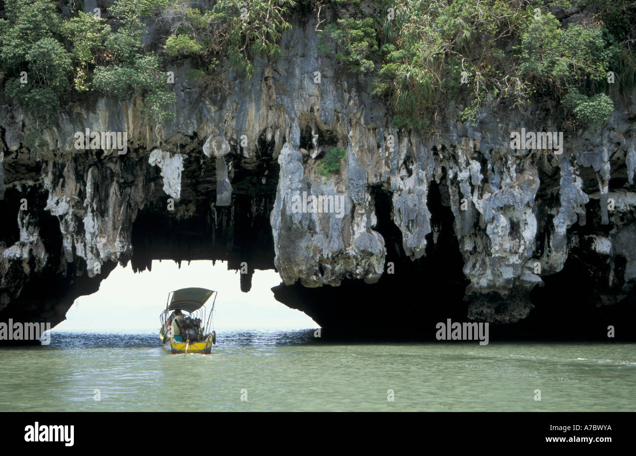 Thai long tail tourist boat going through cave in Phang Na Bay Thailand ...