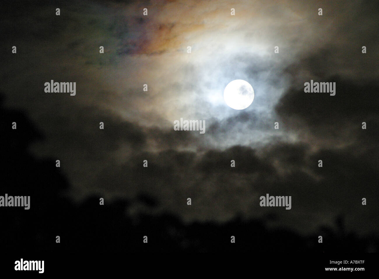 Full moon behind clouds in the night sky Stock Photo - Alamy