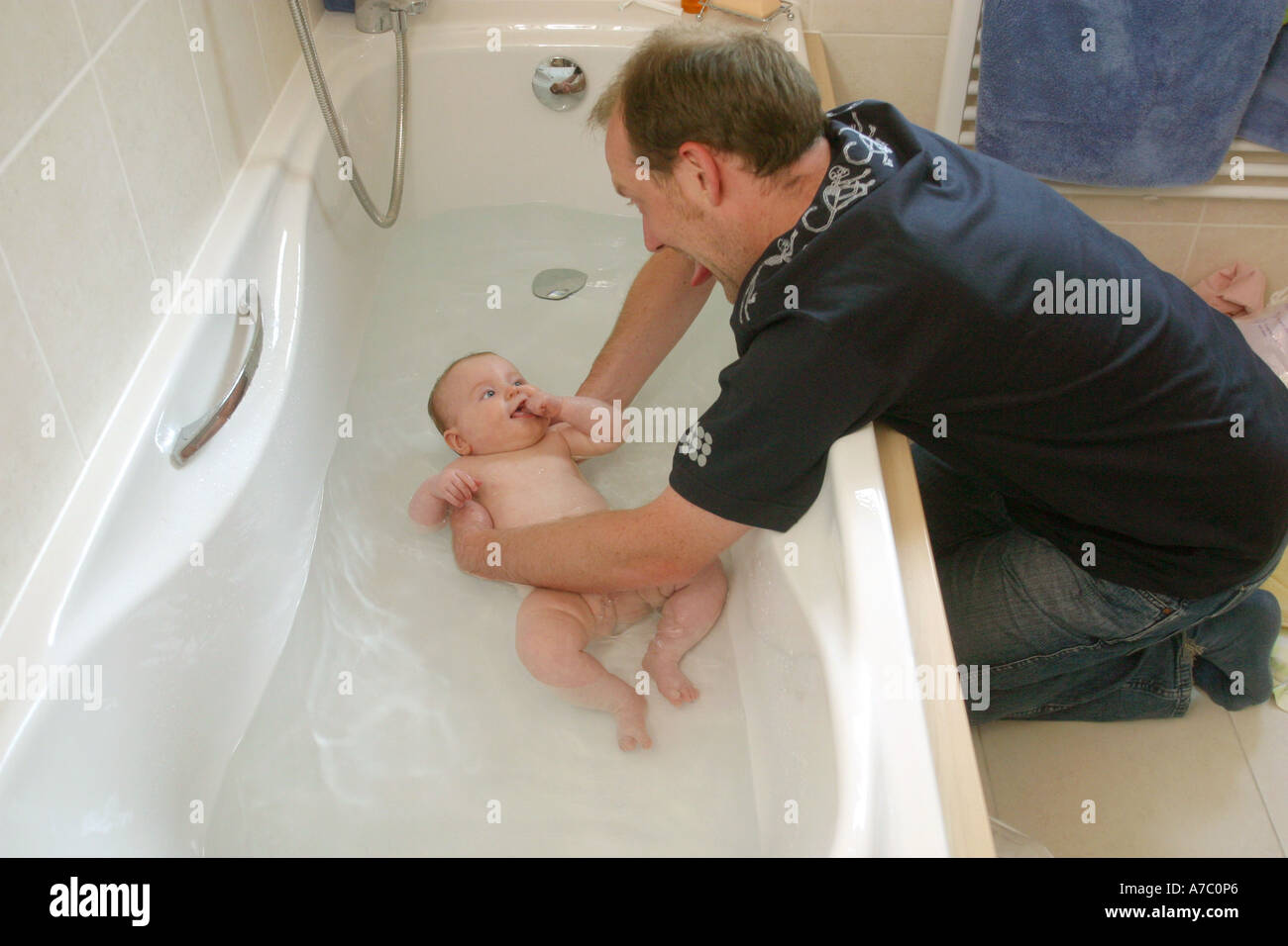 Father bathing his baby hi-res stock photography and images - Alamy