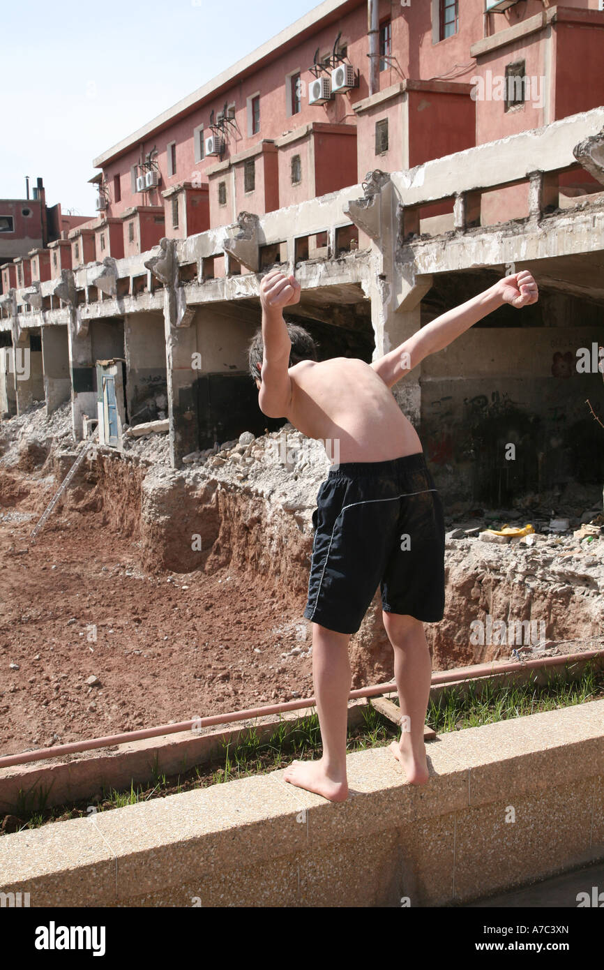 Teen boy pretending to dive into huge hole on contstruction building ...