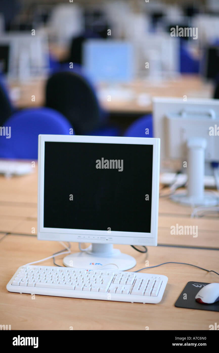 Flat computer monitor screen, keyboard and mouse in large open plan ...