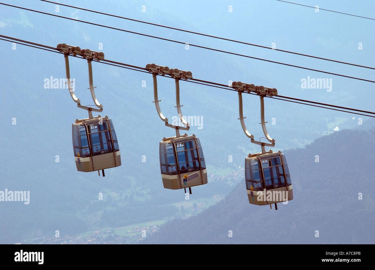 Three cable cars passing in front of mountains in the Swiss Alps ...