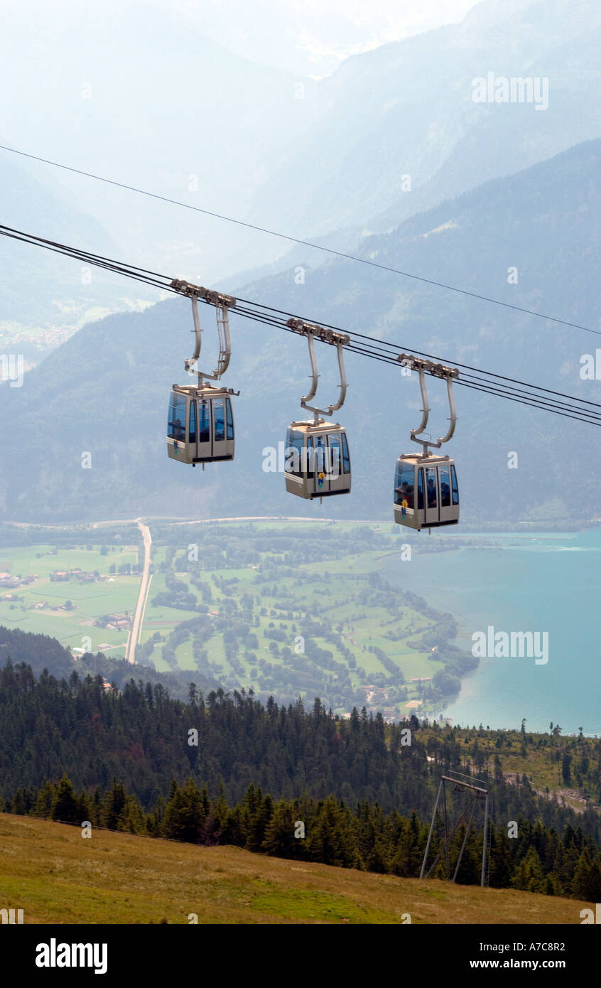 Three cable cars passing in front of mountains in the Swiss Alps ...