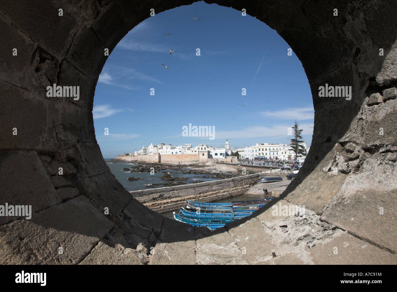 Circular port hole in town walls looking to town walls and medina ...