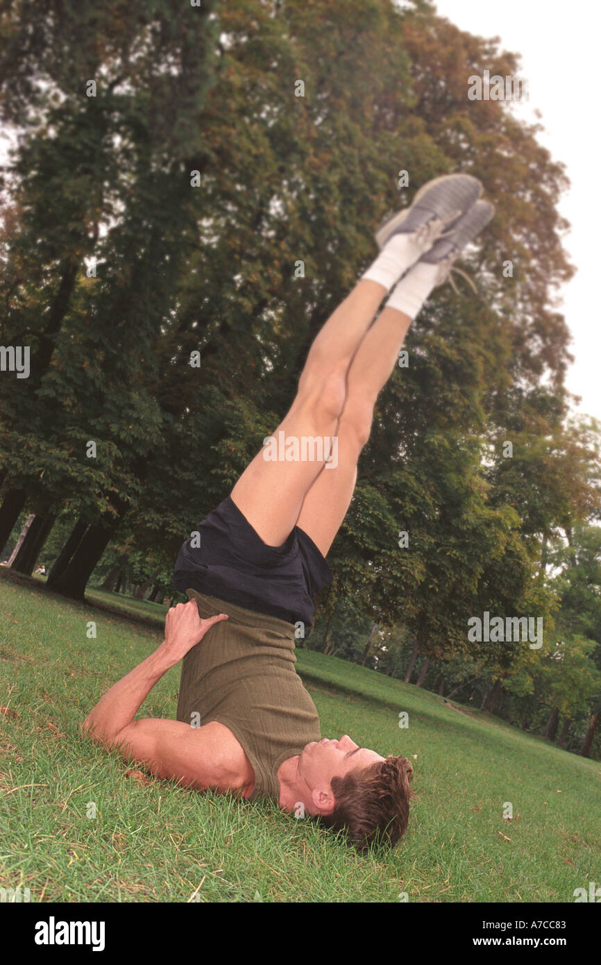 Man stretching his legs up in park Stock Photo - Alamy