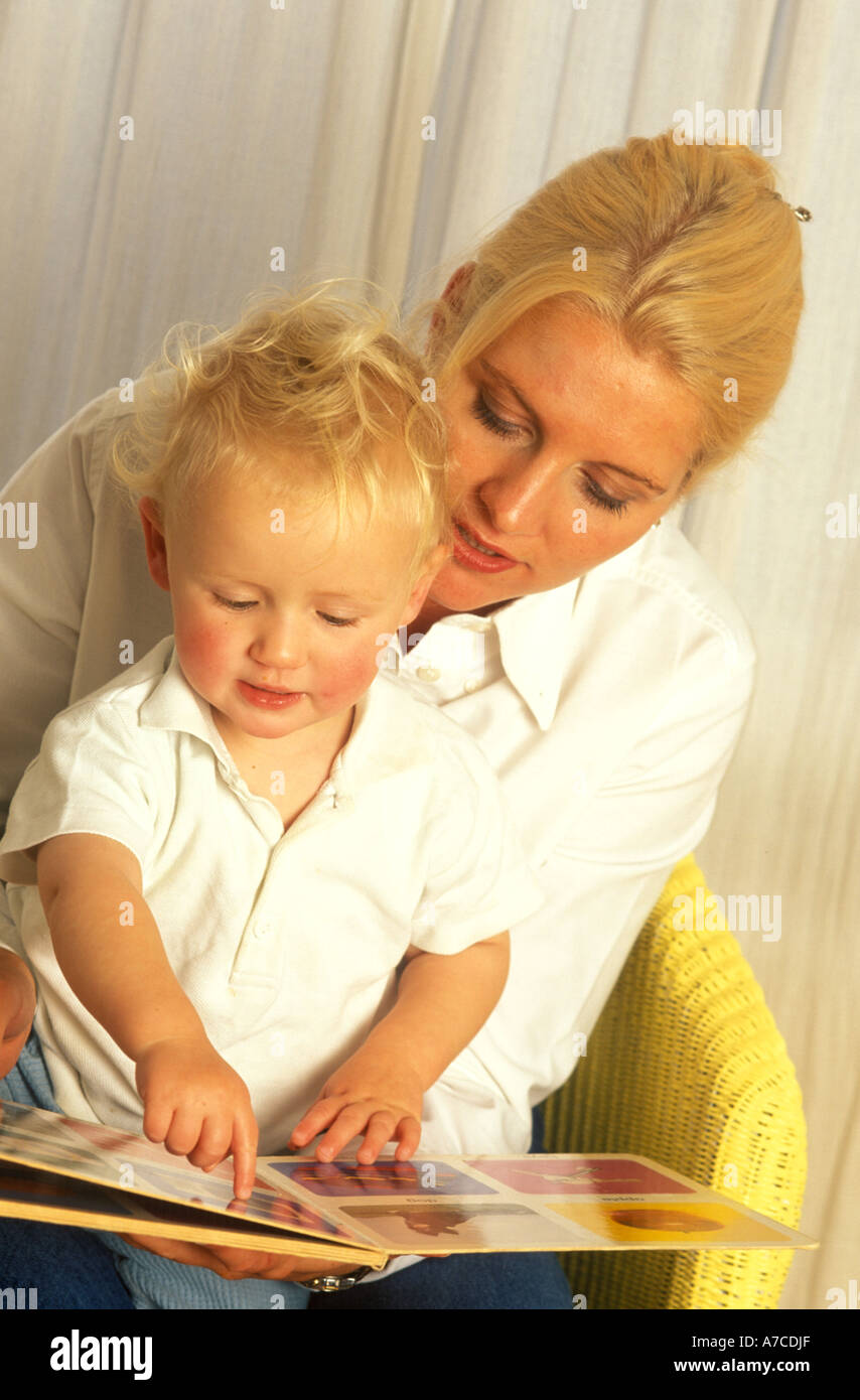 Mother and child reading together toddler pointing Stock Photo - Alamy