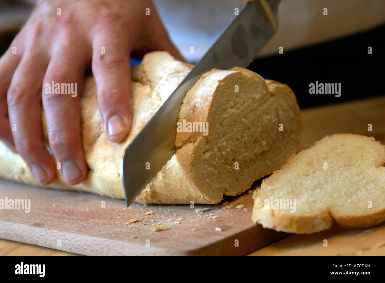 Slicing loaf of bread on a board Stock Photo - Alamy