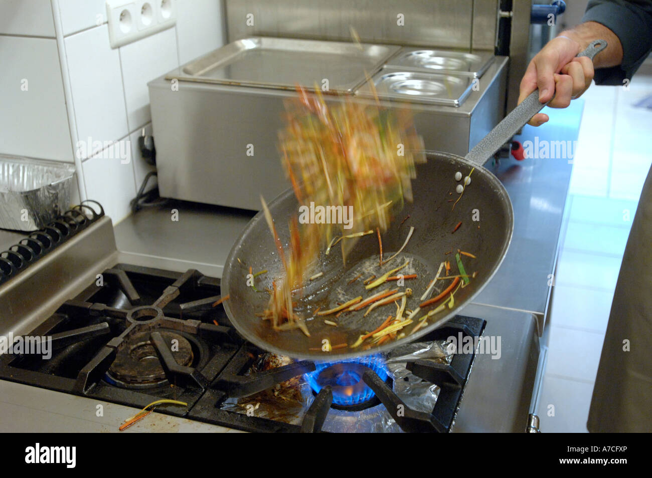 Chef tossing vegetables in a wok Stock Photo - Alamy