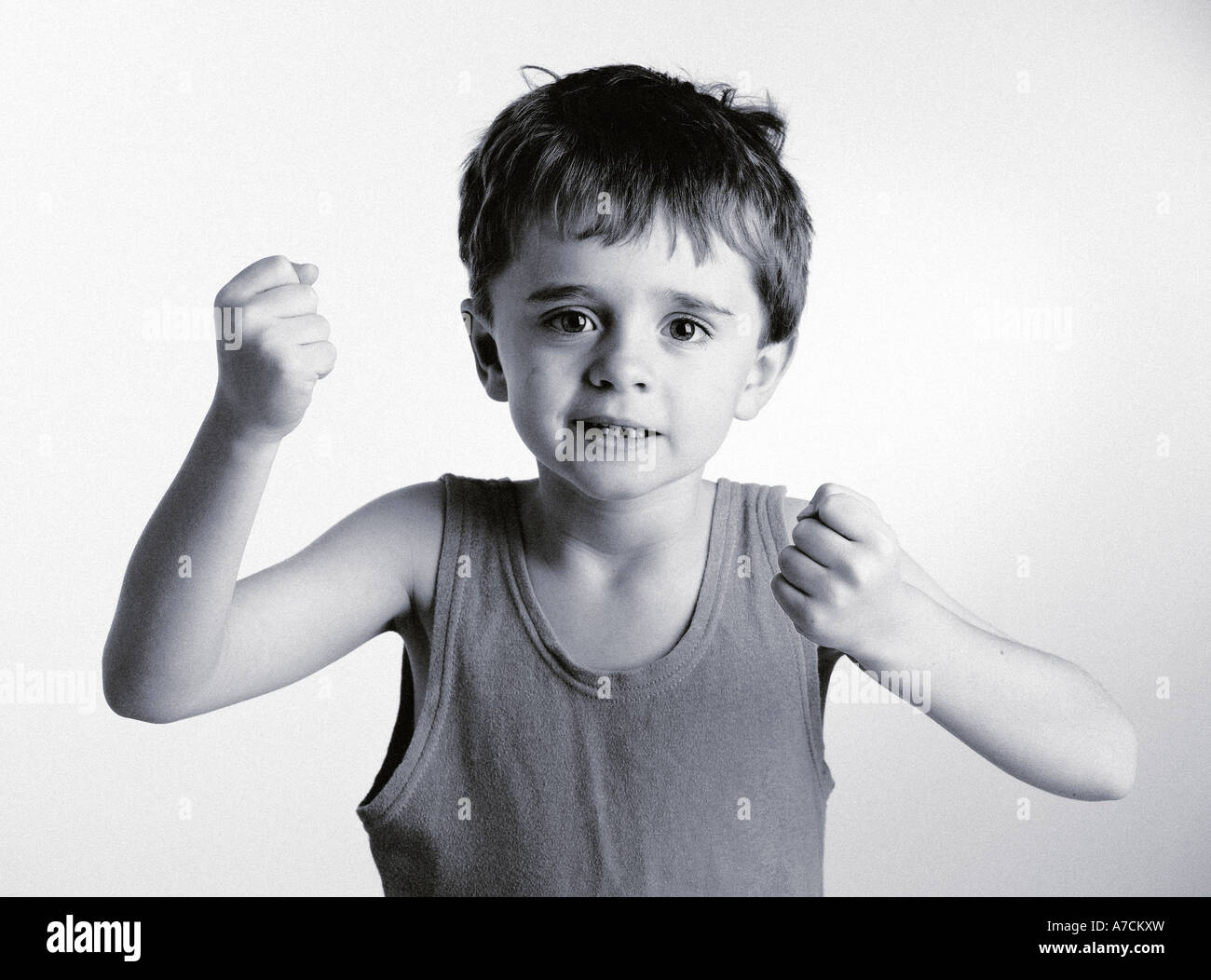 young boy looking aggressive with fists raised Stock Photo - Alamy