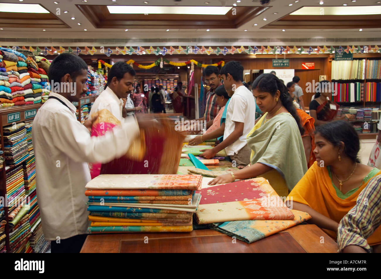 People looking at sarees in Pothys textile store Panagal Park Chennai ...