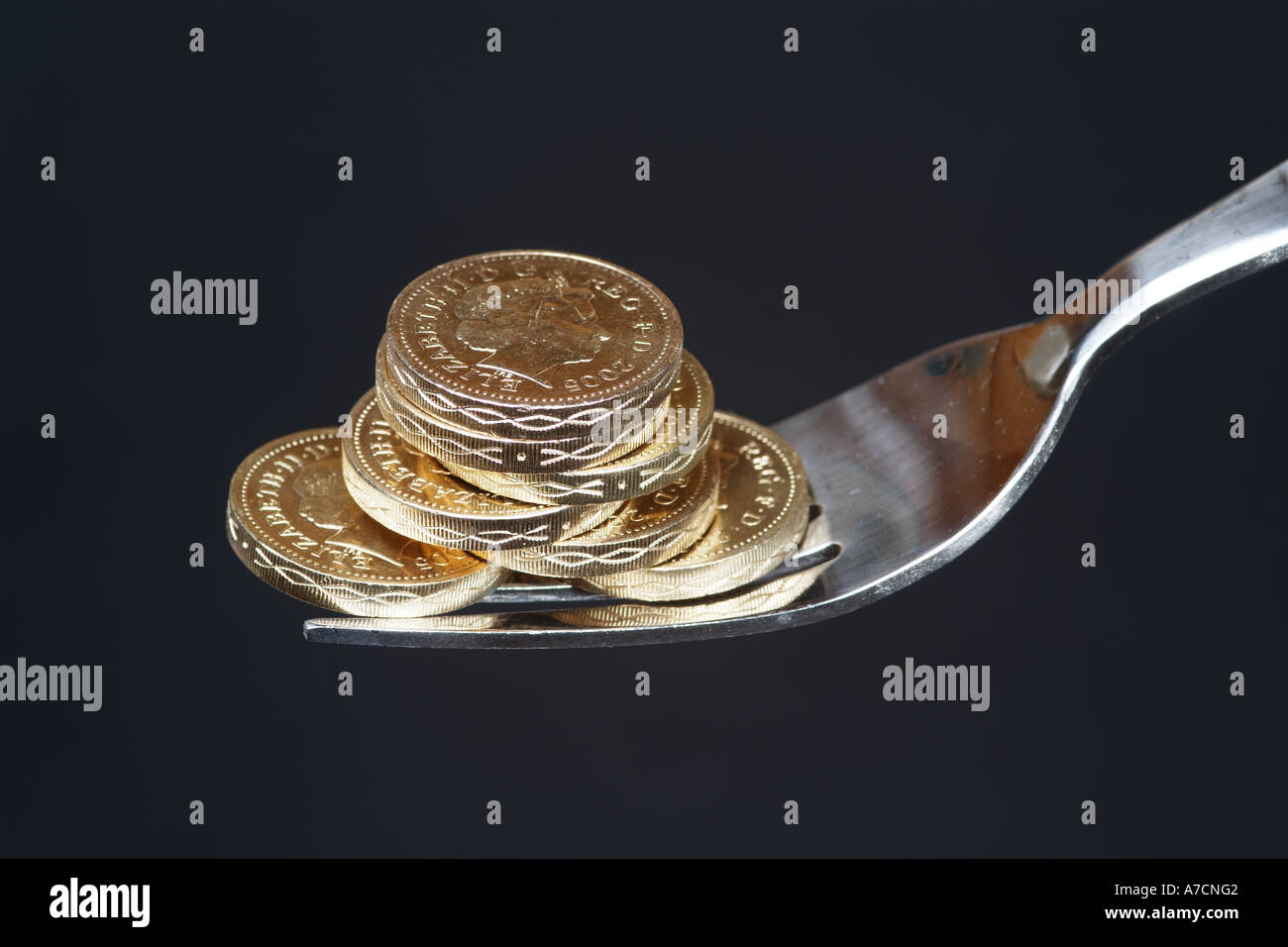 One pound coins balancing on a silver coloured fork. British expression ...