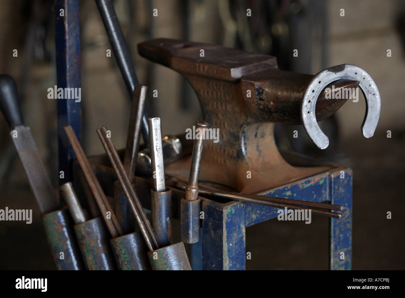 Horse shoe on anvil with blacksmiths traditional tools in stable Stock ...