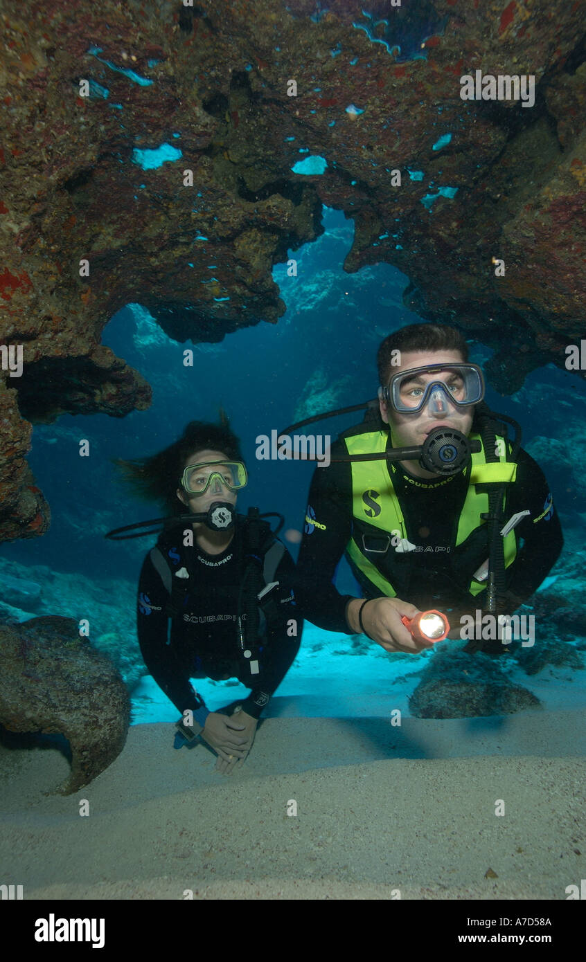 SCUBA DIVERS SWIM THROUGH OPENING IN REEF GRAND CAYMAN Stock Photo - Alamy