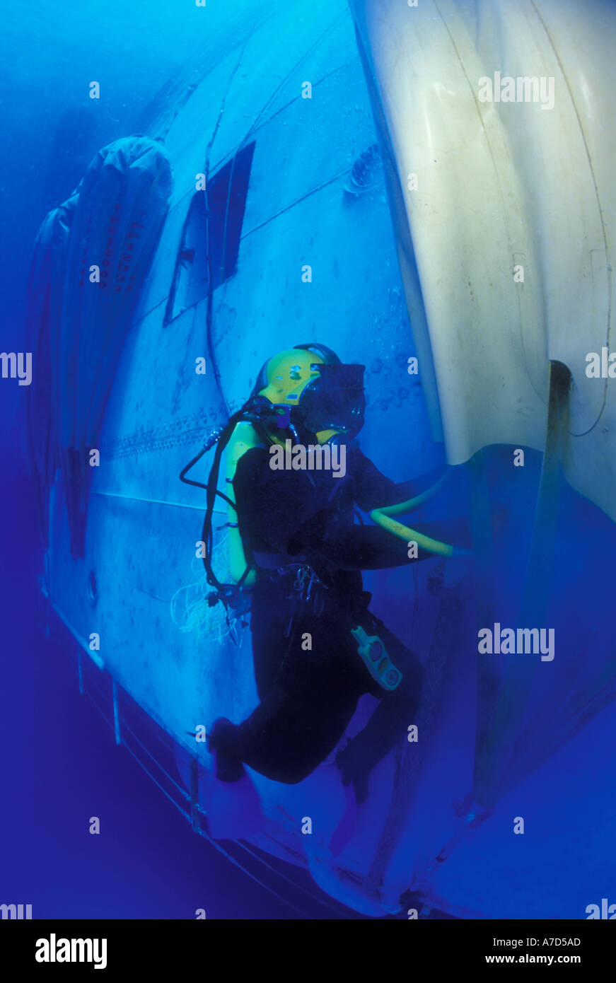 A COMMERCIAL DIVER INFLATES A LIFT BAG TO HELP BUOY THE SPIEGEL GROVE ...
