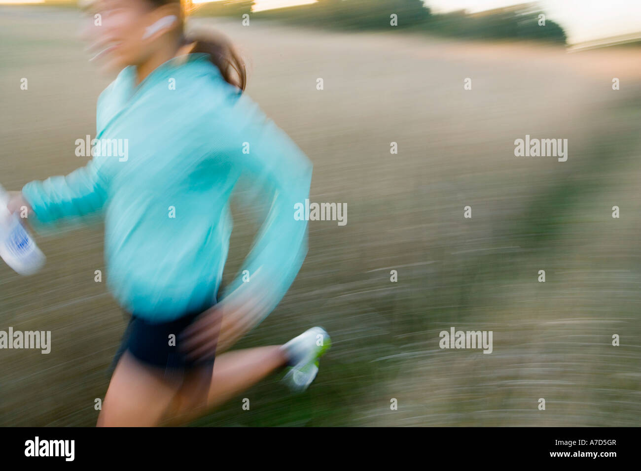 Blurry young woman running with MP3 player Stock Photo - Alamy