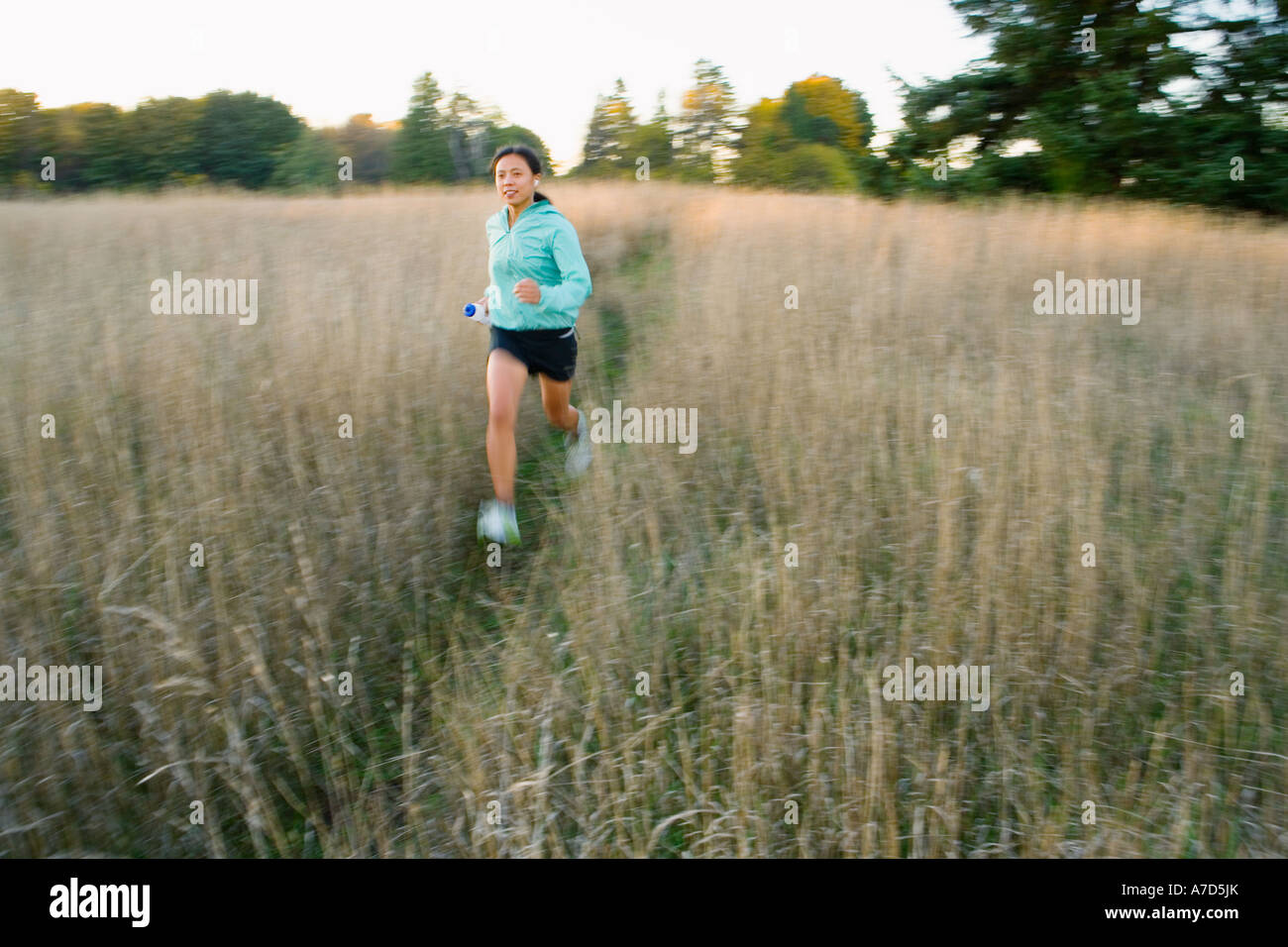 Young woman running with MP3 player Stock Photo - Alamy