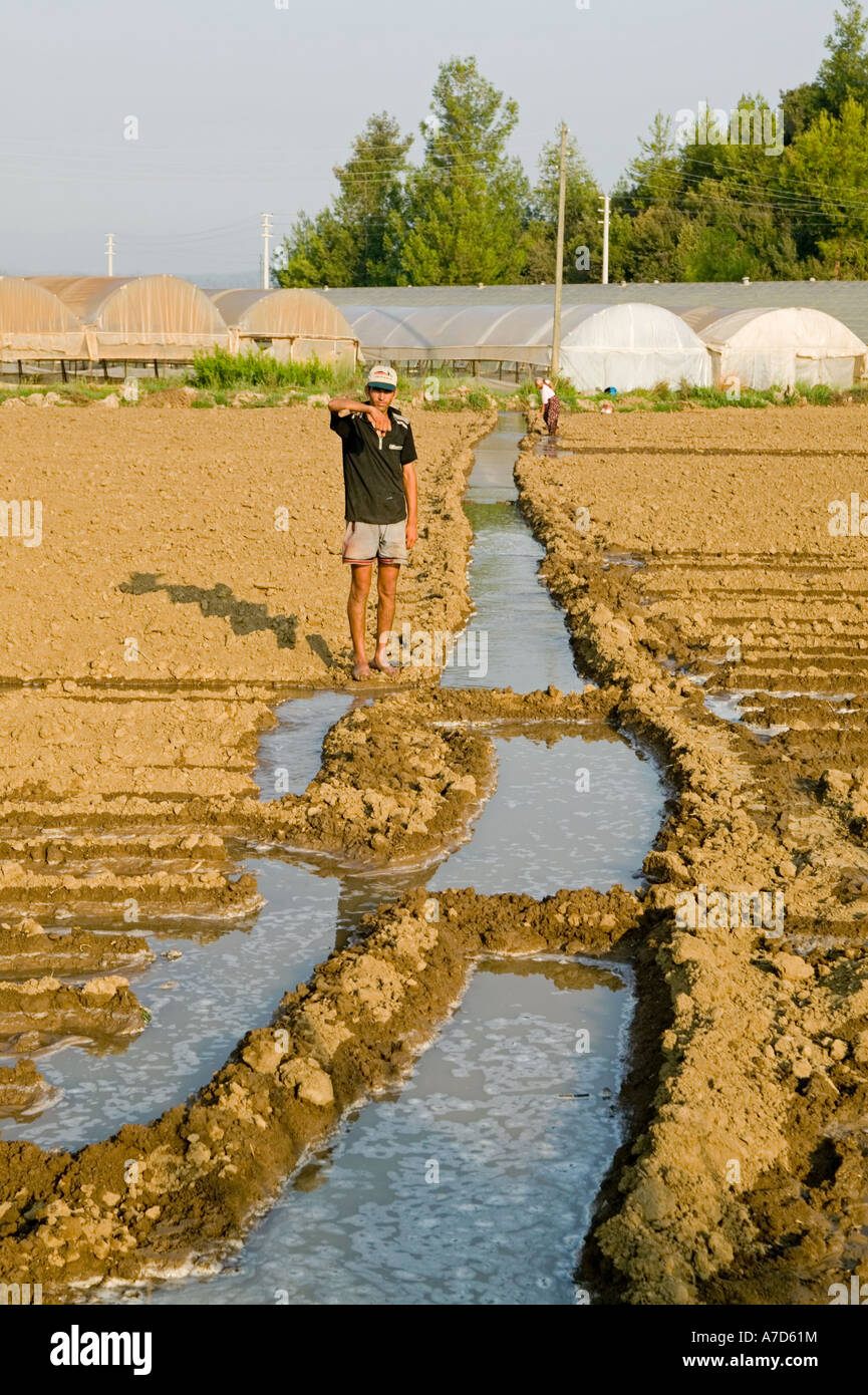 Man opening up irrigation channel before planting potatoes on farmland ...