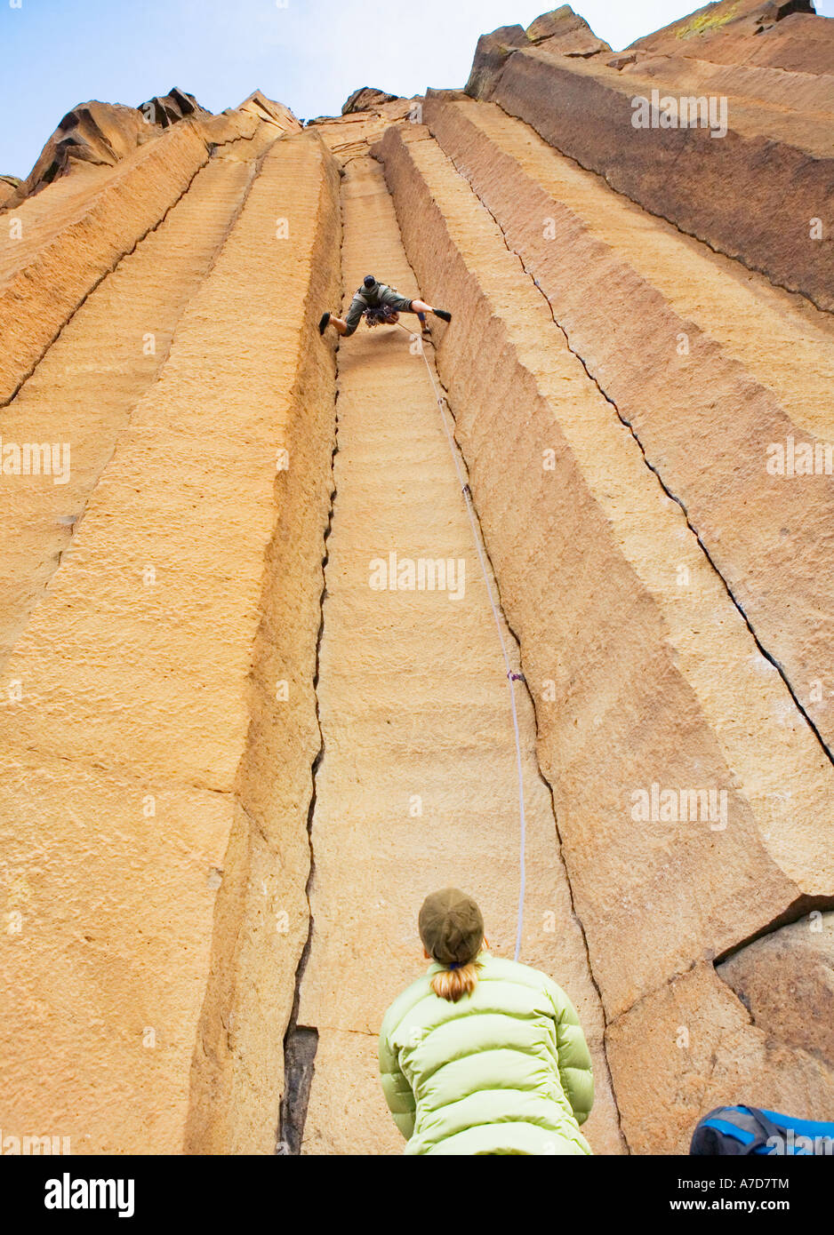A low angle view of two women rock climbing on basalt Columns in ...