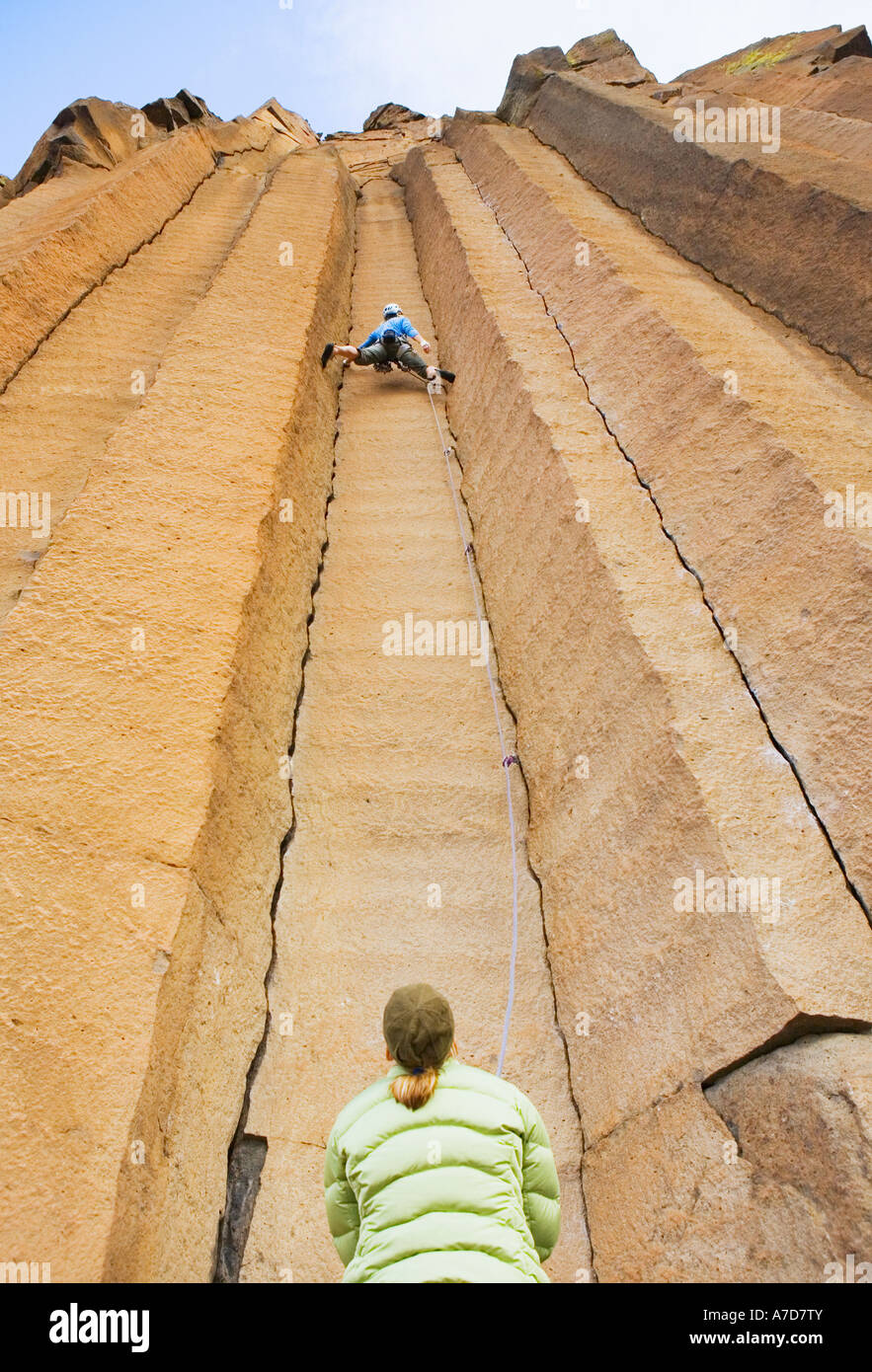 A low angle view of two women rock climbing on basalt Columns in ...