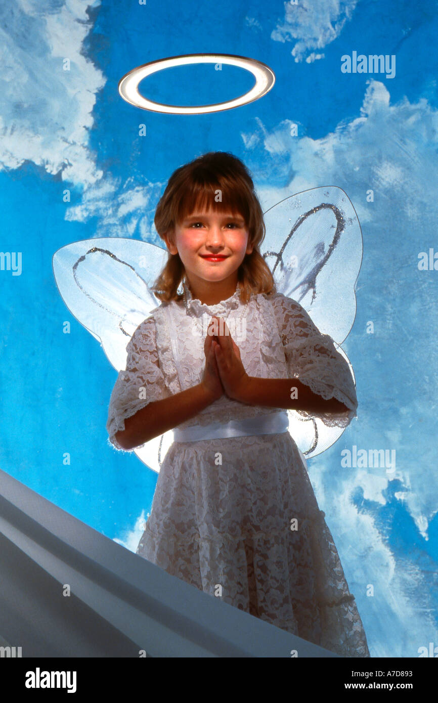 Praying child as angel in heaven with halo Stock Photo - Alamy