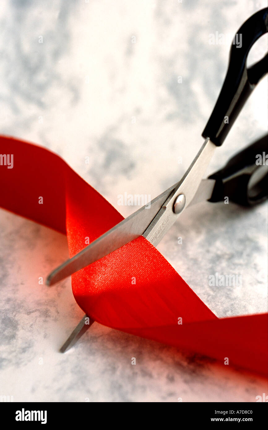Scissors cutting red ribbon Stock Photo - Alamy