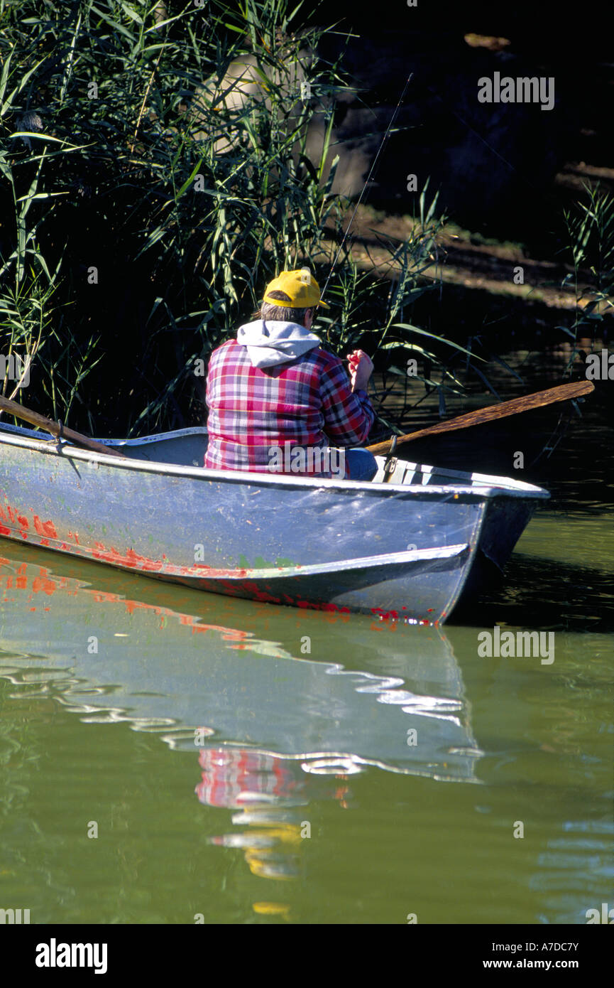Man in row boat fishing Stock Photo - Alamy