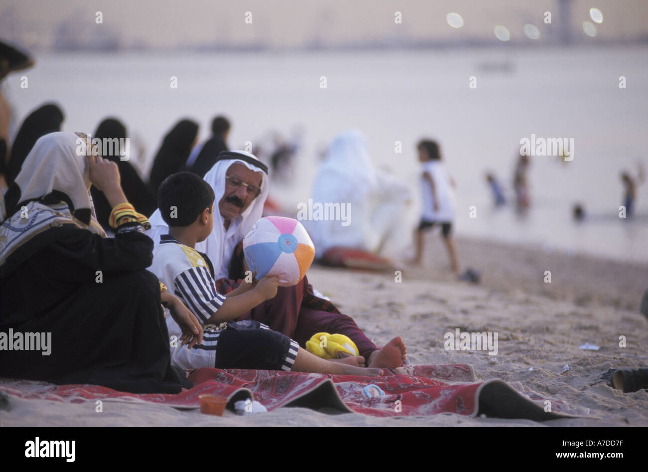 Kuwaitis enjoy an evening sunset on the beach around the capital Stock ...