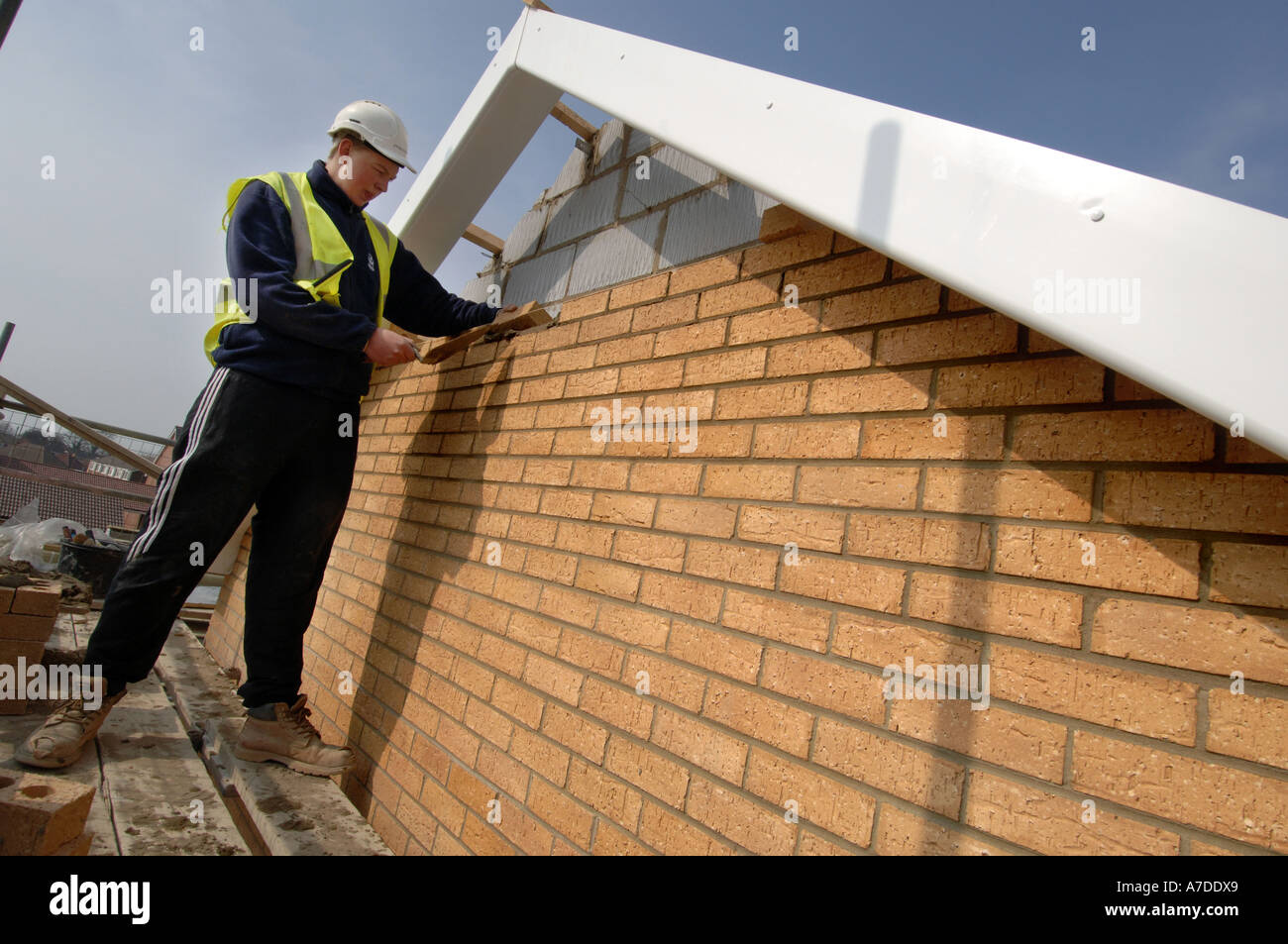 Trainee bricklayer completes a wall on a new housing estate Stock Photo ...