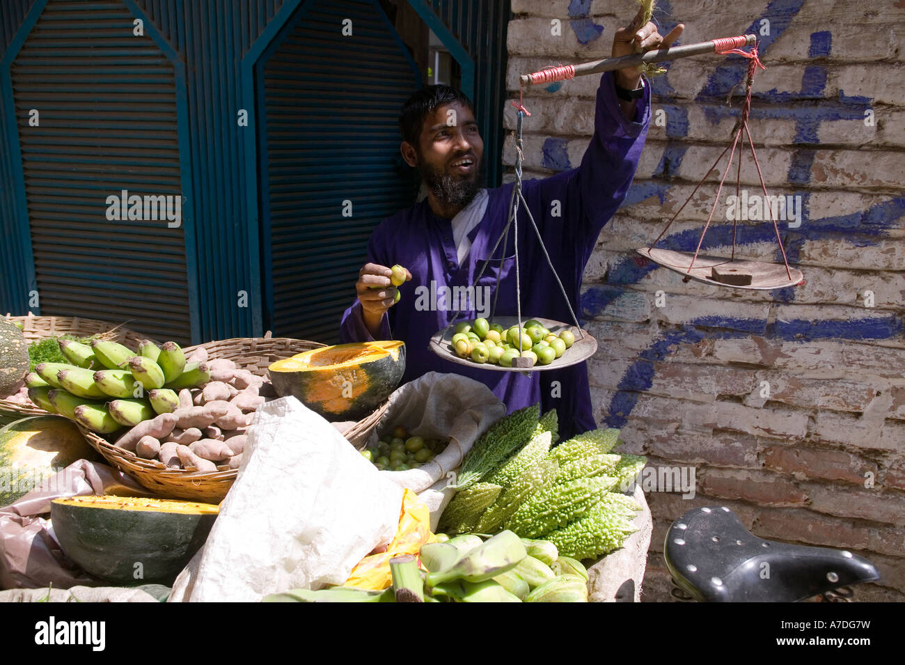 A vegetable vendor weighing vegetables he is selling in Dhaka Bangladesh Stock Photo - Alamy