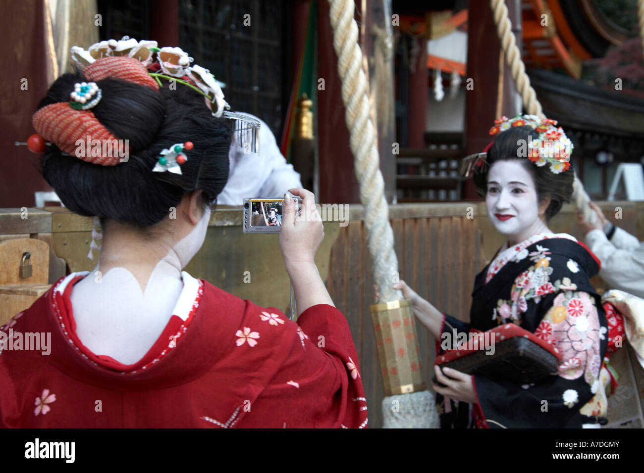 Two women geisha girls taking a picture or photograph visiting Kodaji ...