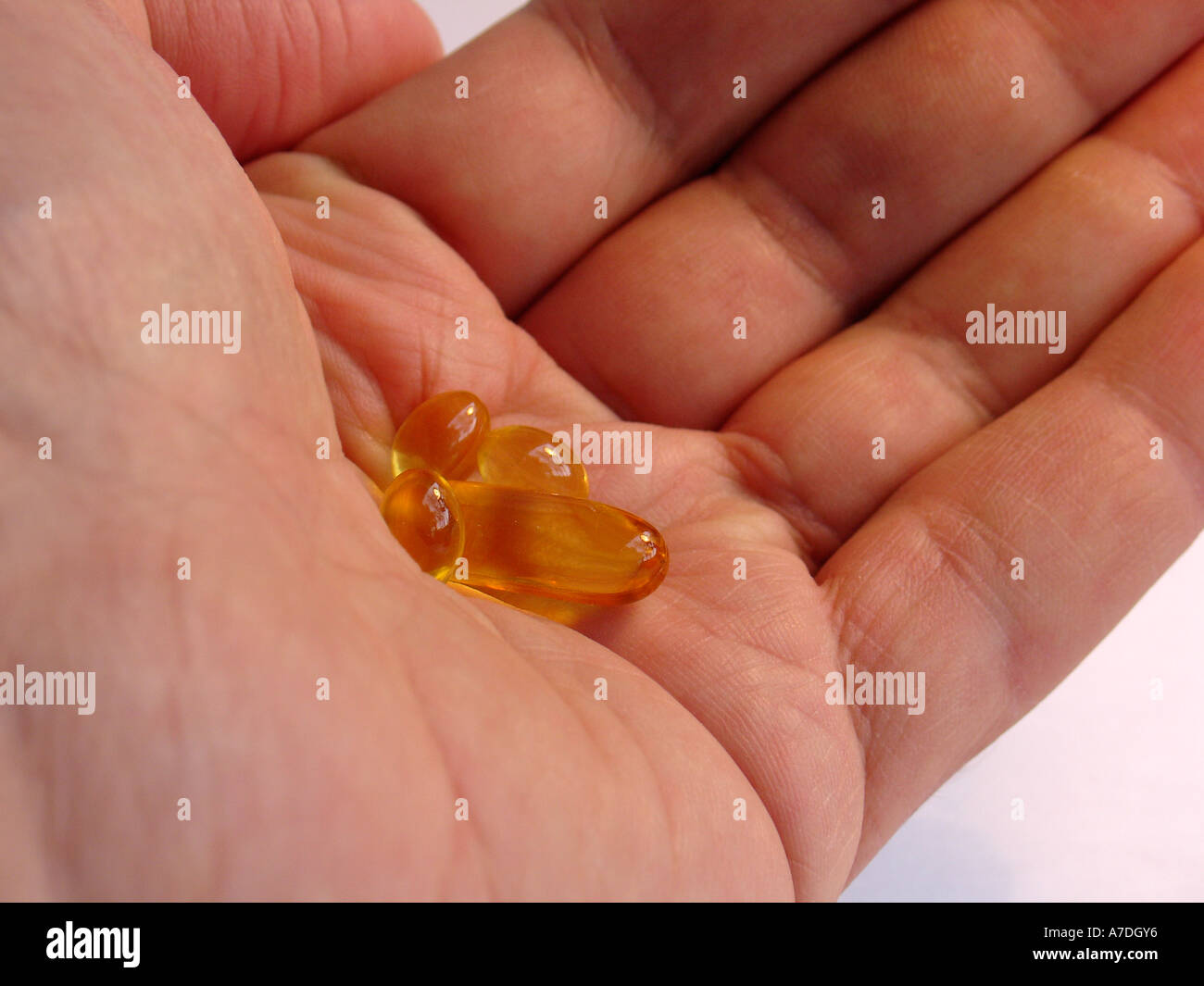 Fish oil capsules medication in open hand palm Stock Photo - Alamy