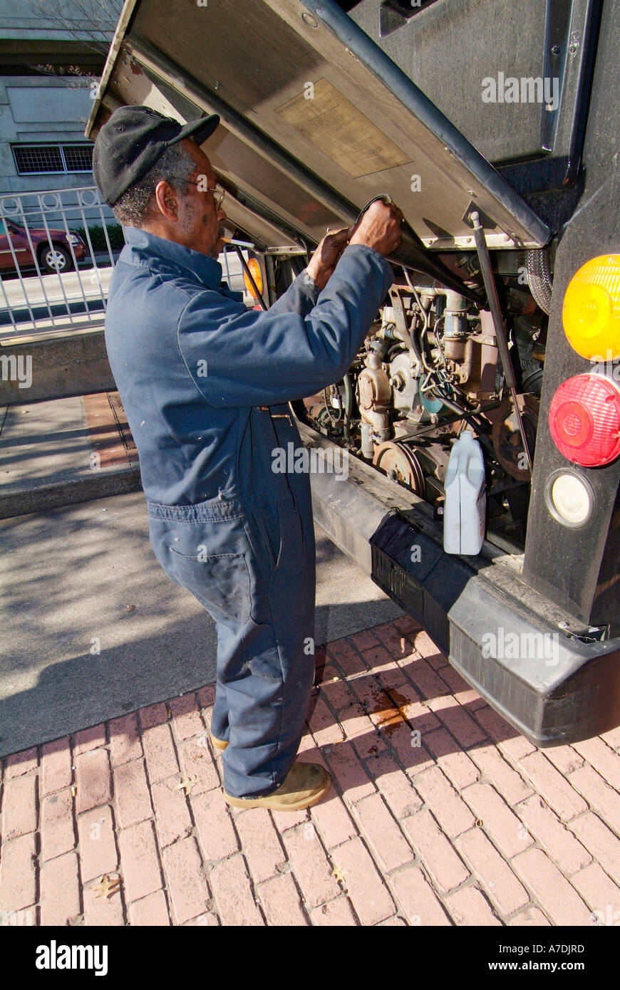 Black male mechanic works to repair a bus engine Stock Photo - Alamy