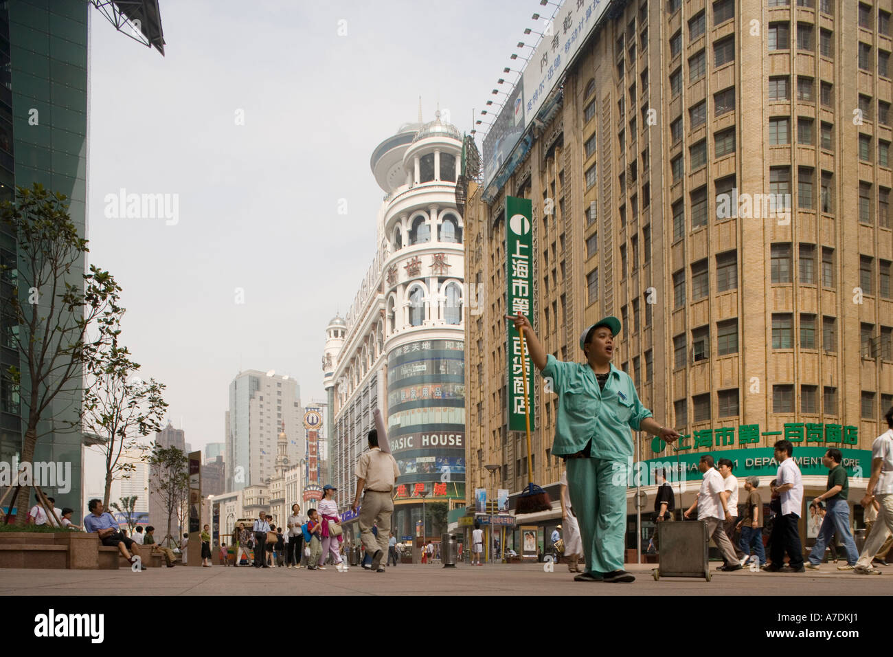 Asia China Shanghai Street cleaner walks along Nanjing Road retail ...